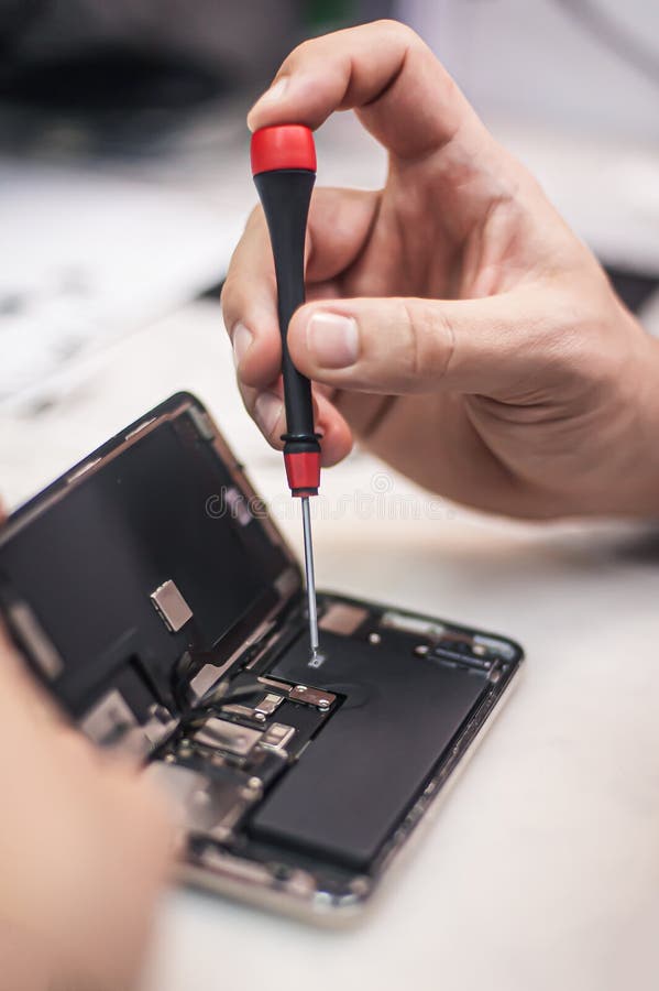Repairman Disassembles Smartphone with Screwdriver in an Electronics ...