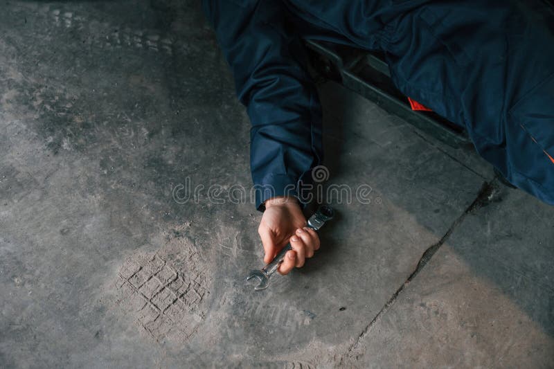 Repairman is Lying Down on the Ground with Tool in Hand Stock Photo ...