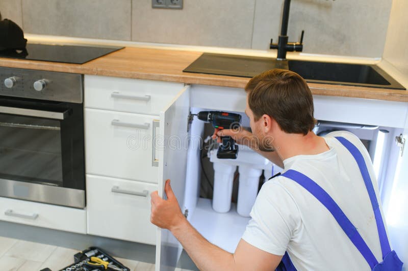 Repairman in Overalls Repairing Cabinet Hinge in Kitchen Stock Image ...