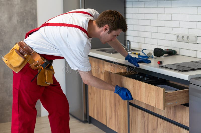 Repairman in Overalls Repairing Cabinet Hinge in Kitchen Stock Image ...