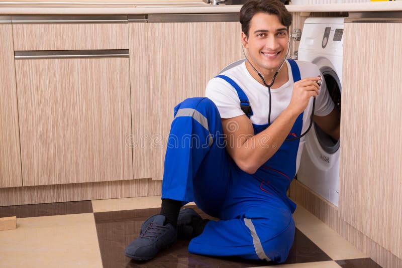 The Repairman Repairing Washing Machine at Kitchen Stock Photo - Image ...