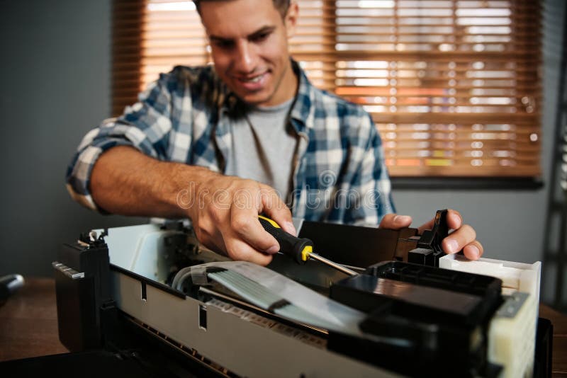 Repairman with Screwdriver Fixing Modern Printer in Office, Focus on ...