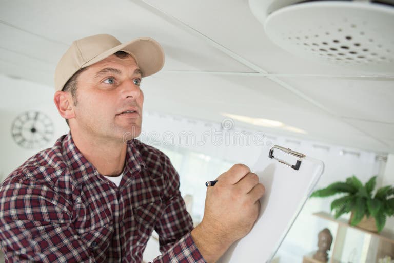 Repairman Standing with Clipboard Checking Ceiling Stock Photo - Image ...