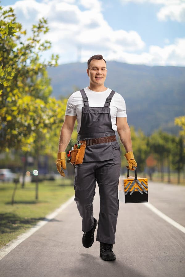Repairman in a Uniform Carrying a Tool Box and Walking Stock Image ...