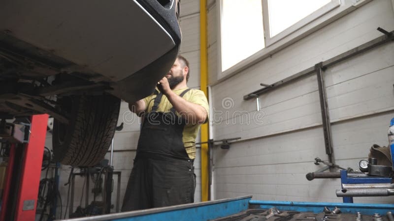 Auto Mechanic Controls Process of Lifting Car on a Lift at Garage ...