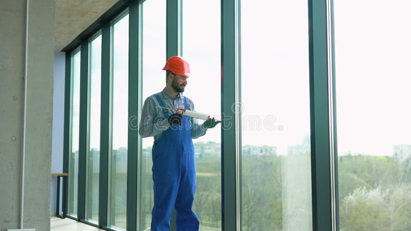 A Repairman in Uniform Installs Pvc Windows in New Office Stock Footage ...