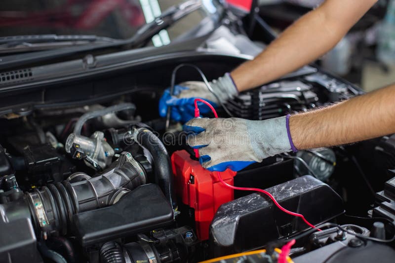 Repairman Using Handheld Digital Multimeter of Car Engine Auto Mechanic ...
