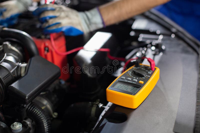 Repairman Using Handheld Digital Multimeter of Car Engine Auto Mechanic ...