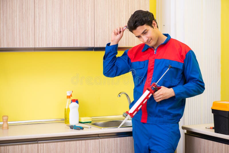 The Repairman Working in the Kitchen Stock Photo - Image of caulking ...