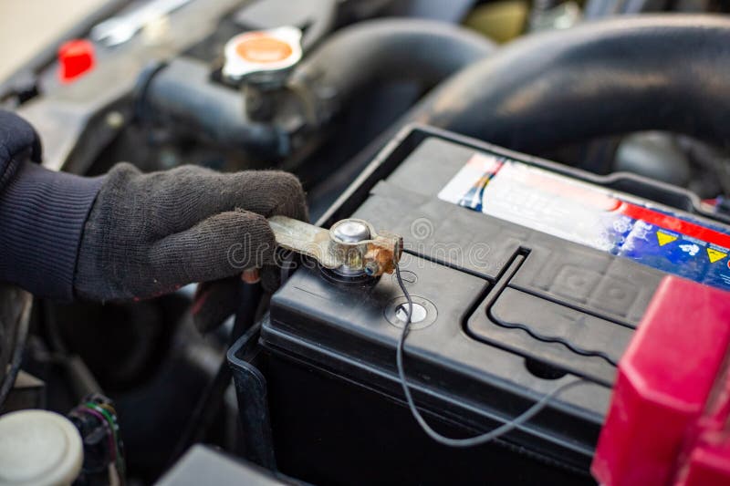 Replacing a Car Battery. a Man Installs a Battery by Putting Terminals ...