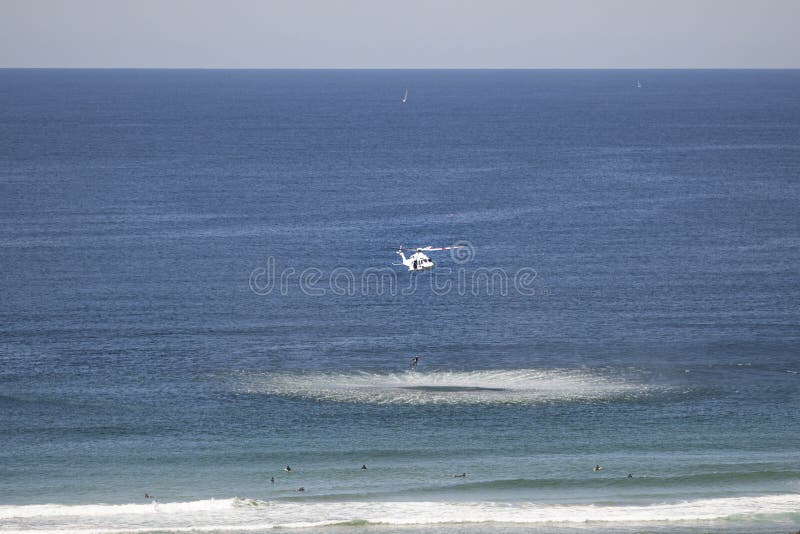 Rescue Helicopter Pulling Surfer Up from Ocean Waves Stock Image ...