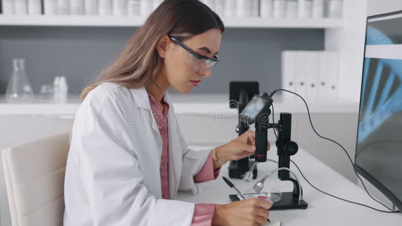 Research, Microscope and Computer with a Woman Writing Notes while ...