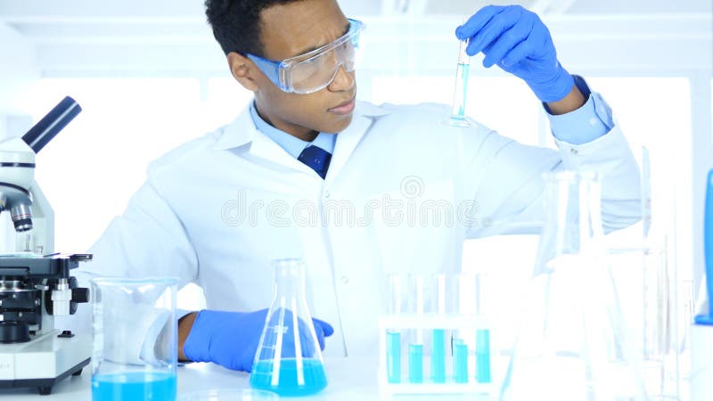 Research Scientist Looking at Blue Solution in Test Tube in Laboratory ...