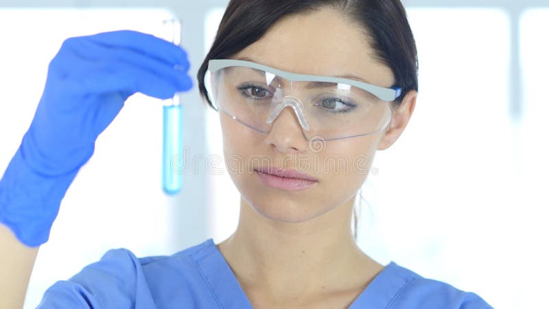 Research Scientist Looking at Blue Solution in Test Tube in Laboratory ...