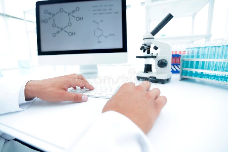 A Scientist Uses a Computer and a Microscope Stock Photo - Image of ...