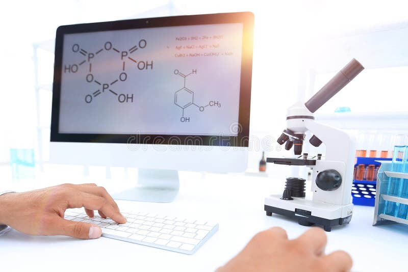 A Scientist Uses a Computer and a Microscope Stock Photo - Image of ...