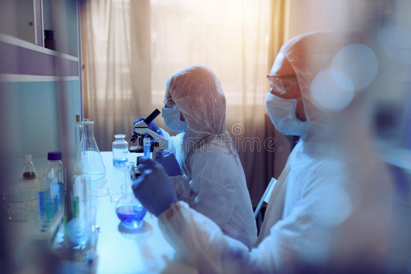 Doctor in the Laboratory Analyzes Samples Under a Microscope ...