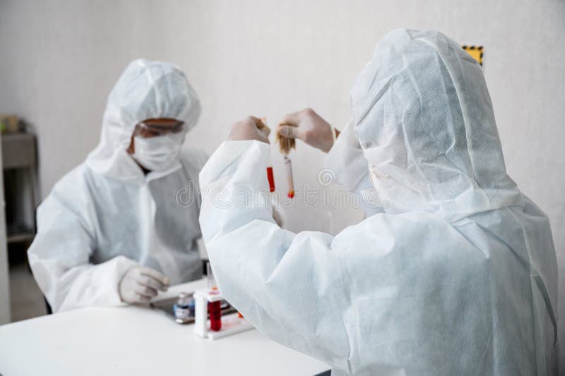 Researchers and Assistant in PPE Analyzing a Sample Blood in Test Tube ...