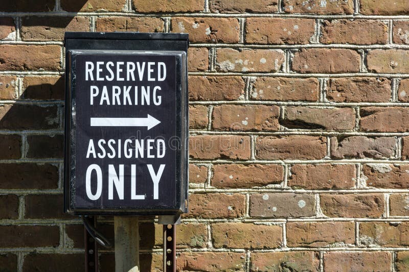 Reserved Parking and Assigned only Sign Against a Red Brick Wall Stock ...