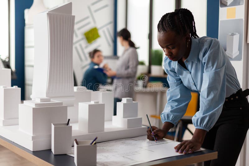 Residential Architect Drawing Blueprints at Desk in Architectural ...