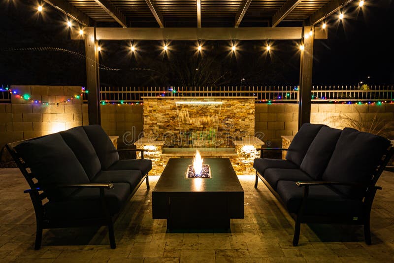 A Resort Style Backyard at Night with a Waterfall, Pergola, and a ...