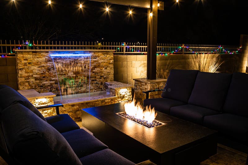 A Resort Style Backyard at Night with a Waterfall, Pergola, and a ...