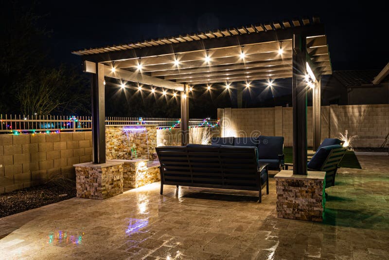 A Resort Style Backyard at Night with a Waterfall, Pergola, and a ...