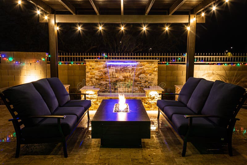 A Resort Style Backyard at Night with a Waterfall, Pergola, and a ...