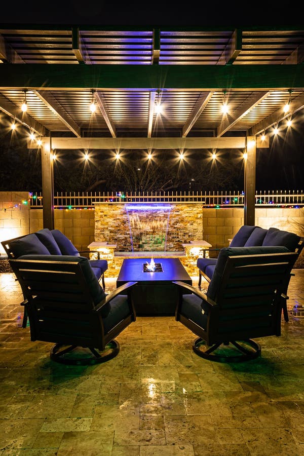 A Resort Style Backyard at Night with a Waterfall, Pergola, and a ...