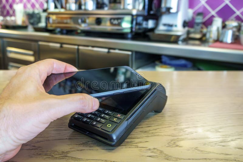 A Restaurant Customer Using a Smartphone To Pay at a Payment Terminal ...