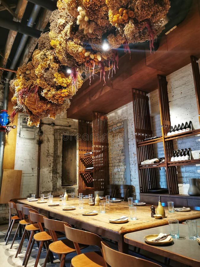 A Restaurant Interior with Long Table and Artificial Plants ...