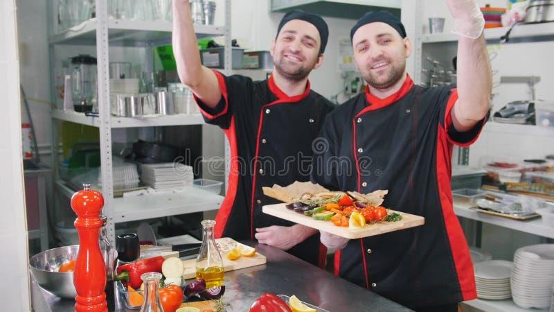 Restaurant Kitchen. Two Men Chefs Finished Serving Dishes with a ...