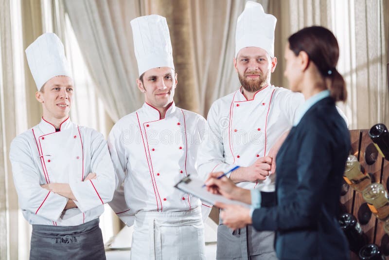 Restaurant Manager and His Staff in Kitchen. Interacting To Head Chef ...