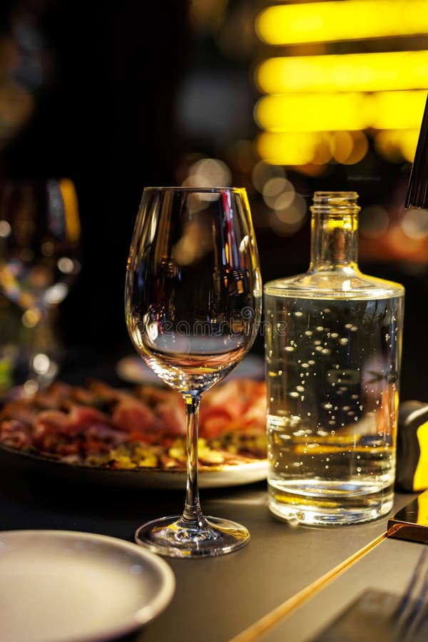 Restaurant Table Illuminated by Warm Lighting, Featuring an Empty Wine ...
