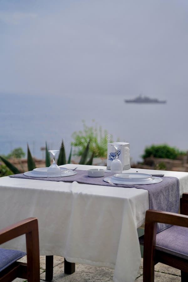 A Restaurant Table with a View of the Ocean is Set for Two Stock Photo ...