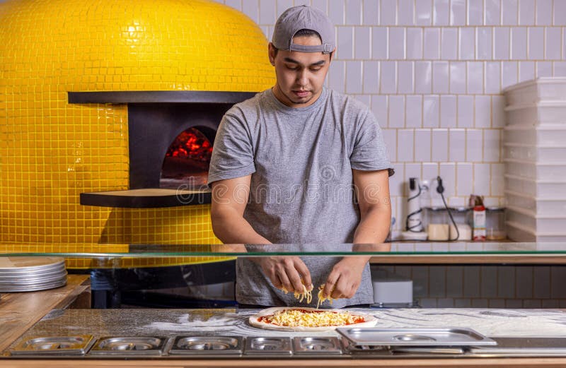 Restaurant Workers Make Pizza, Laying on the Base of Pizza the Grated ...