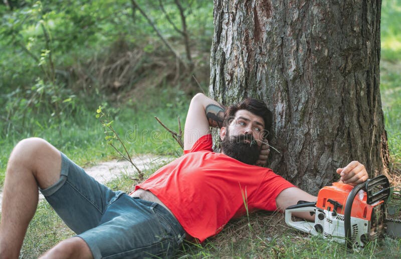 Resting after Hard Work. Lumberjack Worker with Chainsaw in the Forest ...