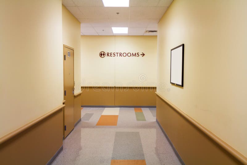 Restroom Sign at the End of a Hallway Stock Image - Image of ...