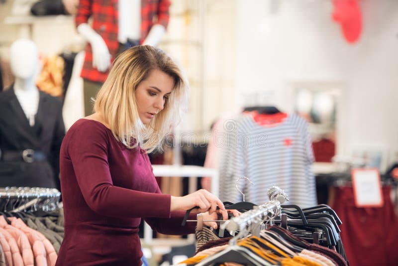 A Retail Store Employee Organising Clothes on a Rail Stock Photo ...