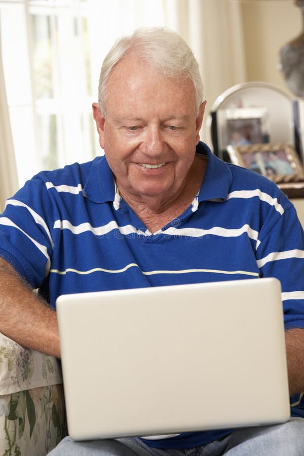 Retired Senior Man Sitting on Sofa at Home Using Laptop Stock Photo ...
