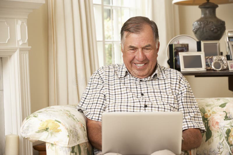 Retired Senior Man Sitting on Sofa at Home Using Laptop Stock Photo ...