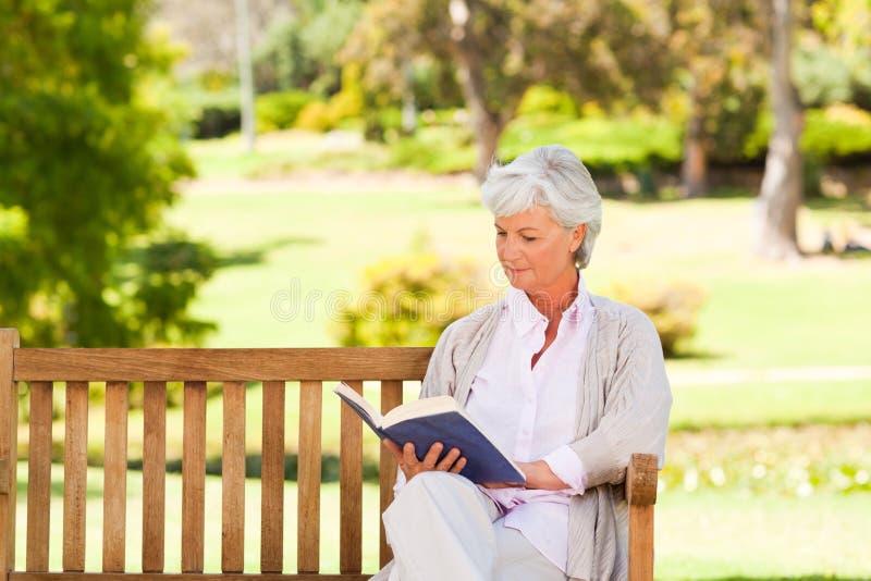 Woman Reading Book in a Park Stock Photo - Image of citizen, outdoor ...
