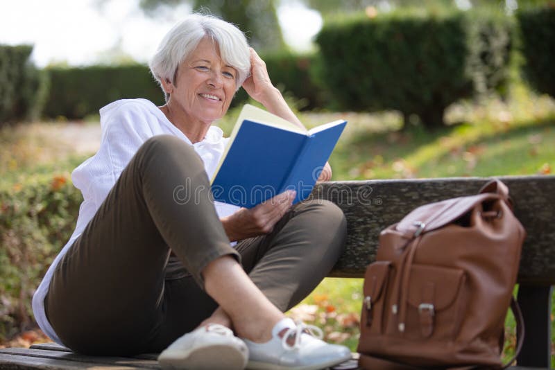 Retired Woman Reading Book on Bench Stock Photo - Image of camera, park ...
