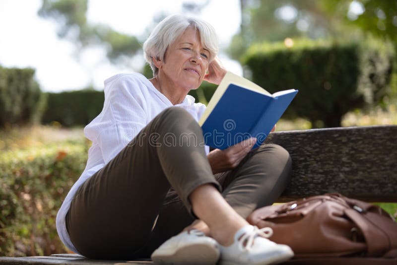 Retired Woman Reading Book on Bench Stock Photo - Image of romance ...