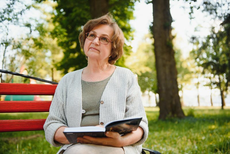 Retired Woman Reading a Book on the Bench Stock Image - Image of older ...