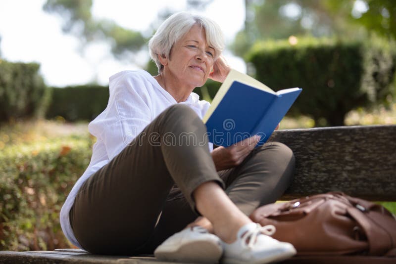 Retired Woman Reading Book on Bench Stock Image - Image of female, love ...