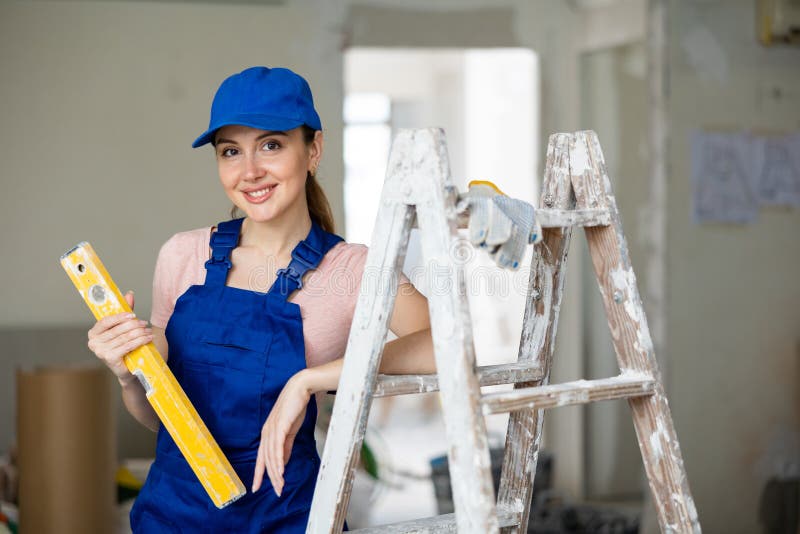 Retrato De Mujer Constructora En Overoles Azules Con Nivel De Edificio ...