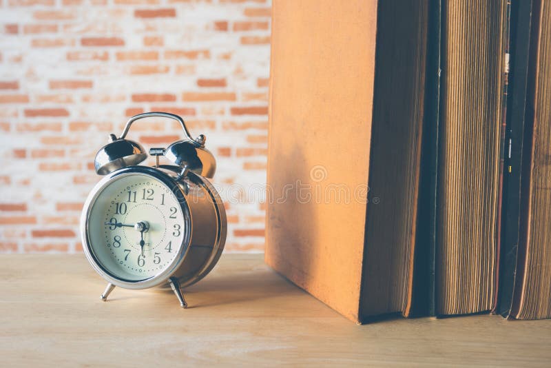 Retro Alarm Clock with Row Book on Wood Table Stock Image - Image of ...
