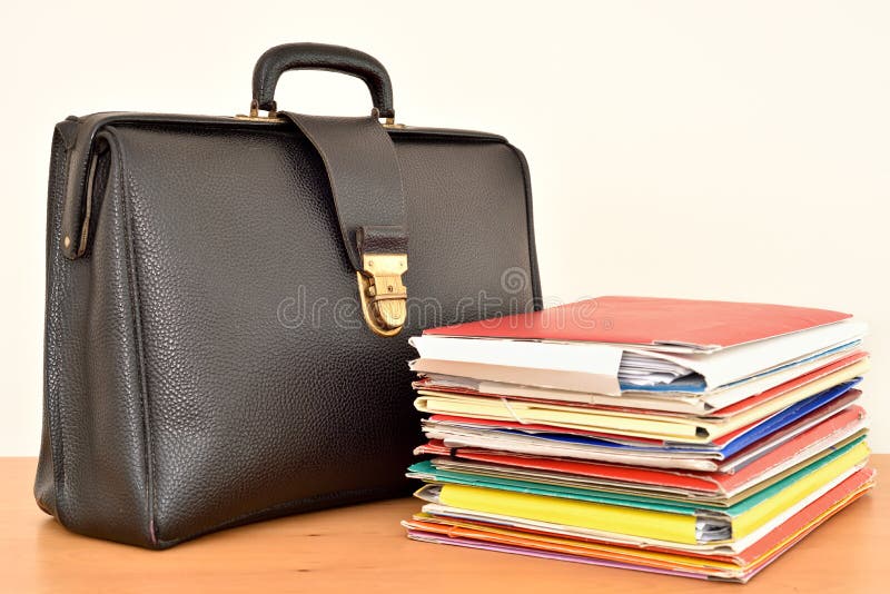 Retro Black Leather Briefcase and Stack of Files on the Brown Wooden ...