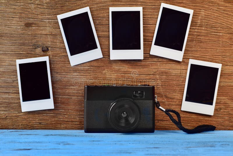 Retro camera and blank instant photos on a wooden surface, A retro ...